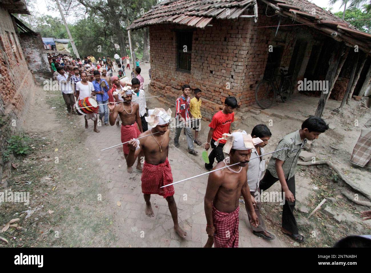 Hindu devotees with metal rods pierced through their tongues walk in a ...