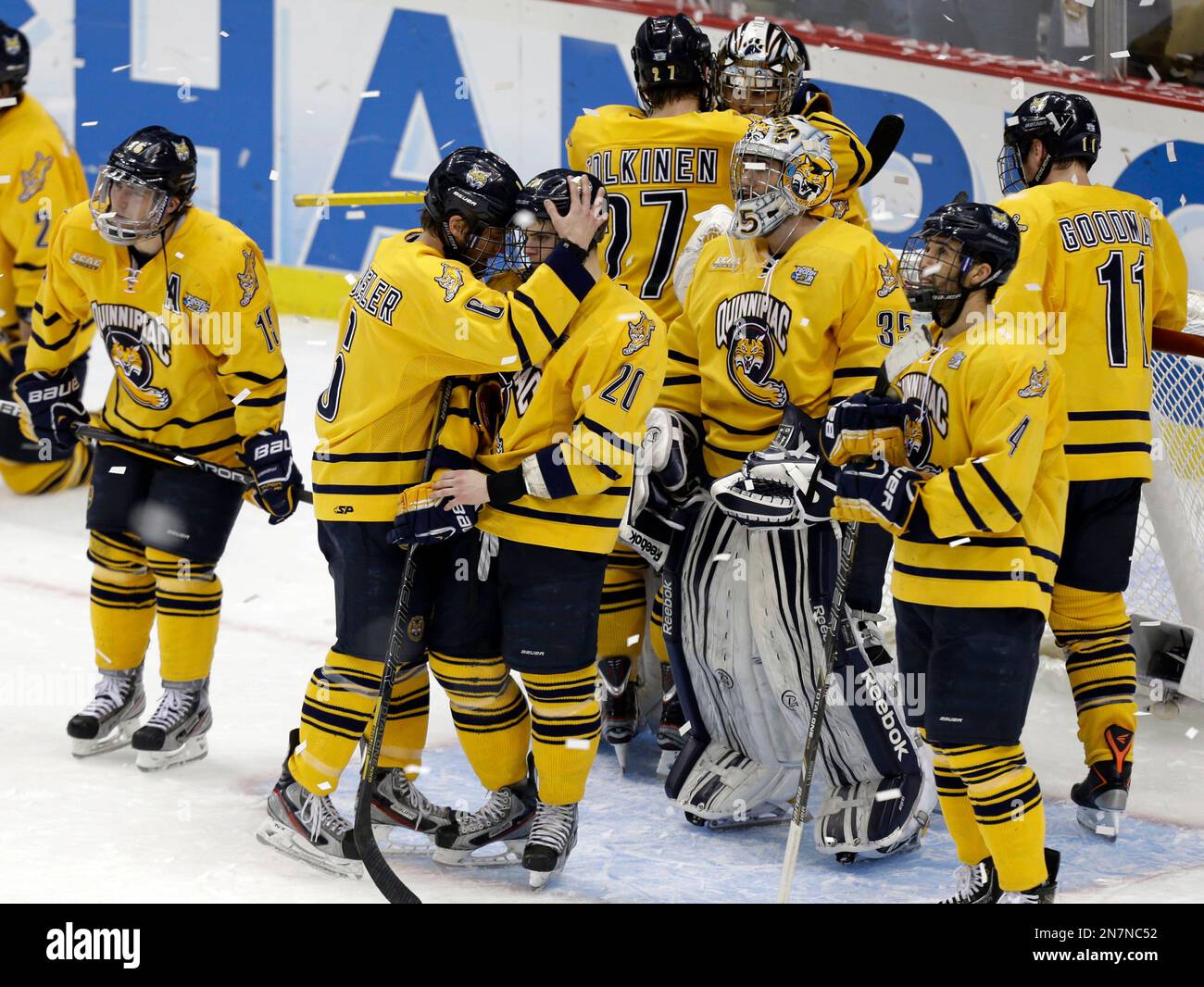 The Quinnipiac men's hockey team gather around goalie Eric Hartzell ...