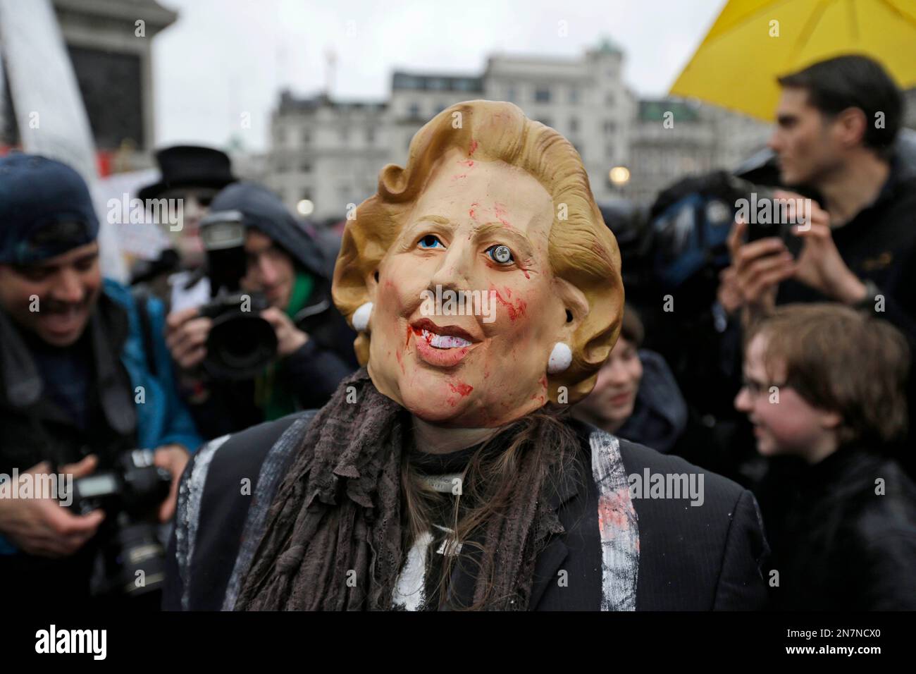 A protester wears a mask depicting former British Prime Minister ...