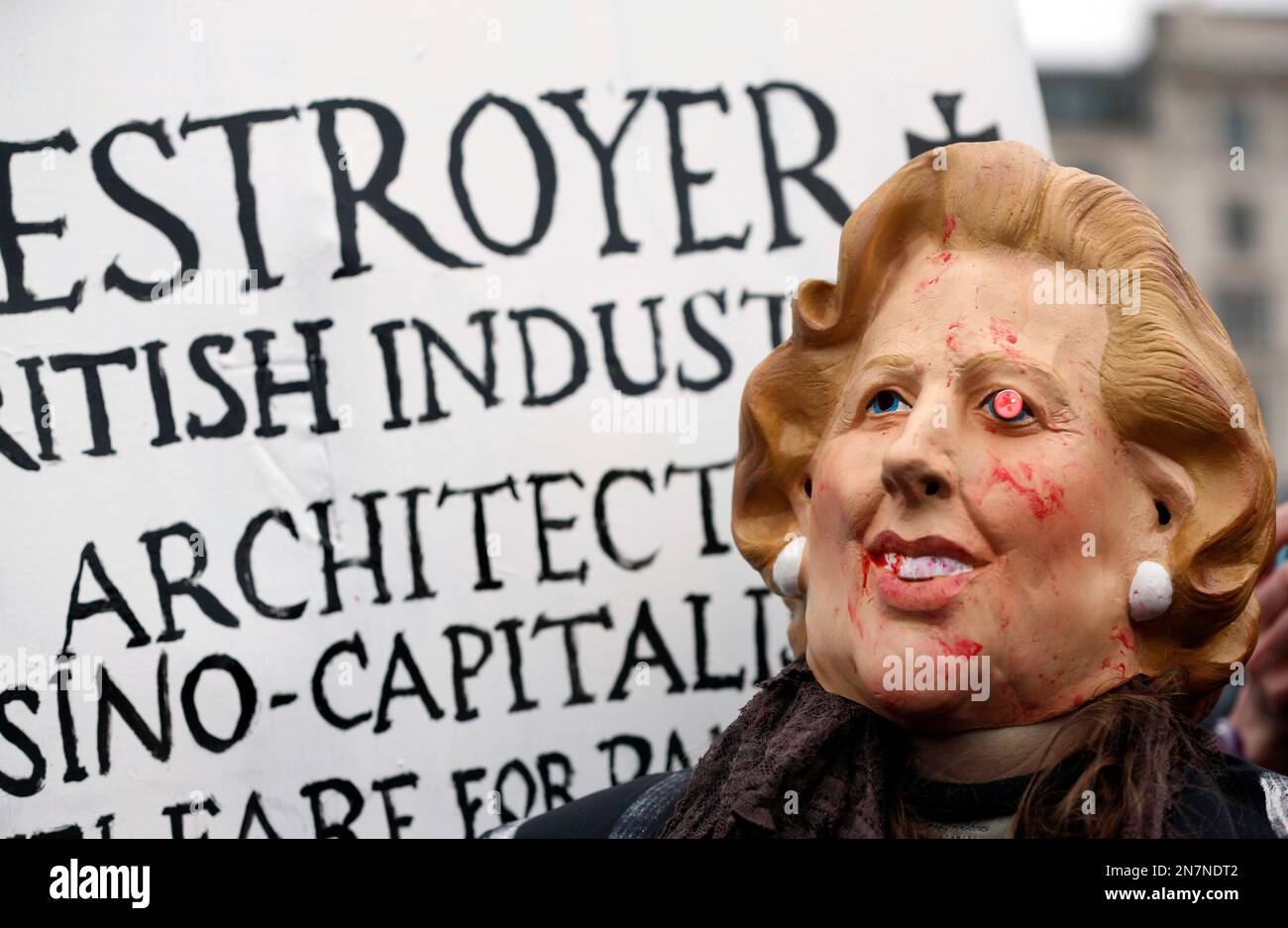 A protester wears a mask depicting former British Prime Minister ...
