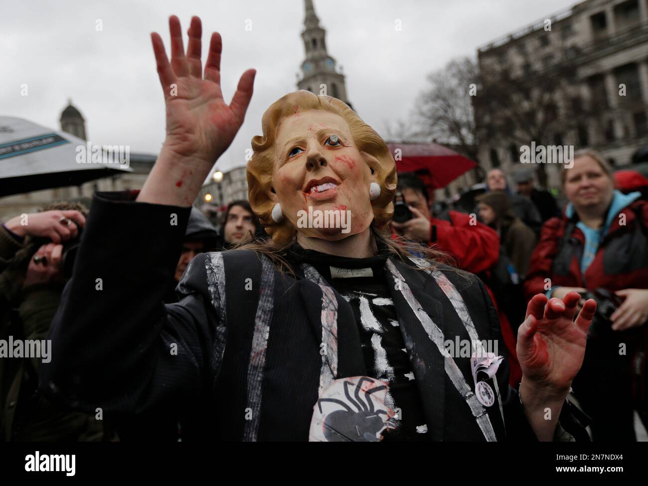 A protester wears a mask depicting former British Prime Minister ...