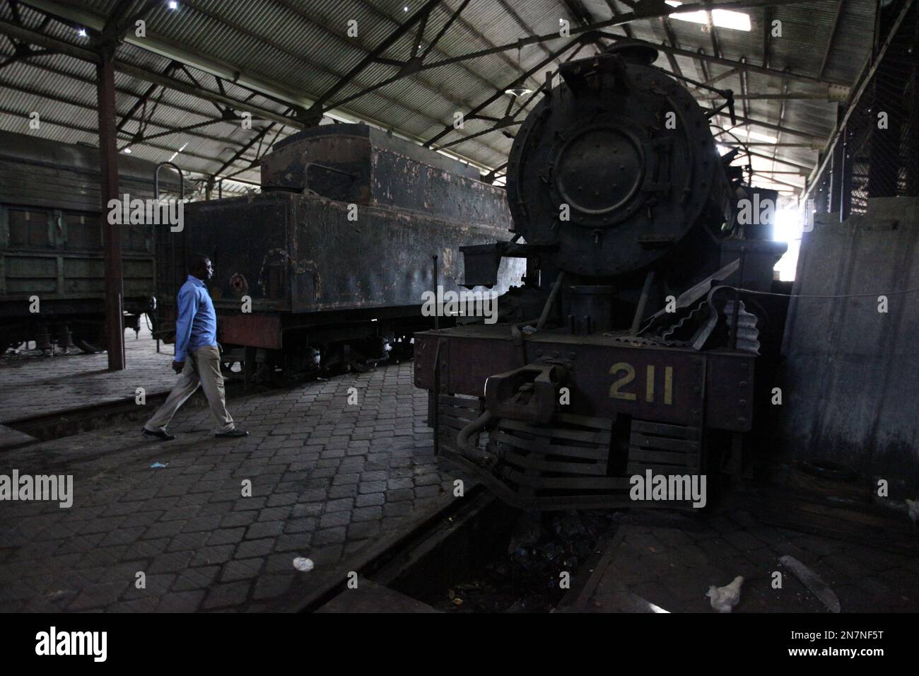 A man walks past an abandoned steam locomotive in Lagos, Nigeria, on ...