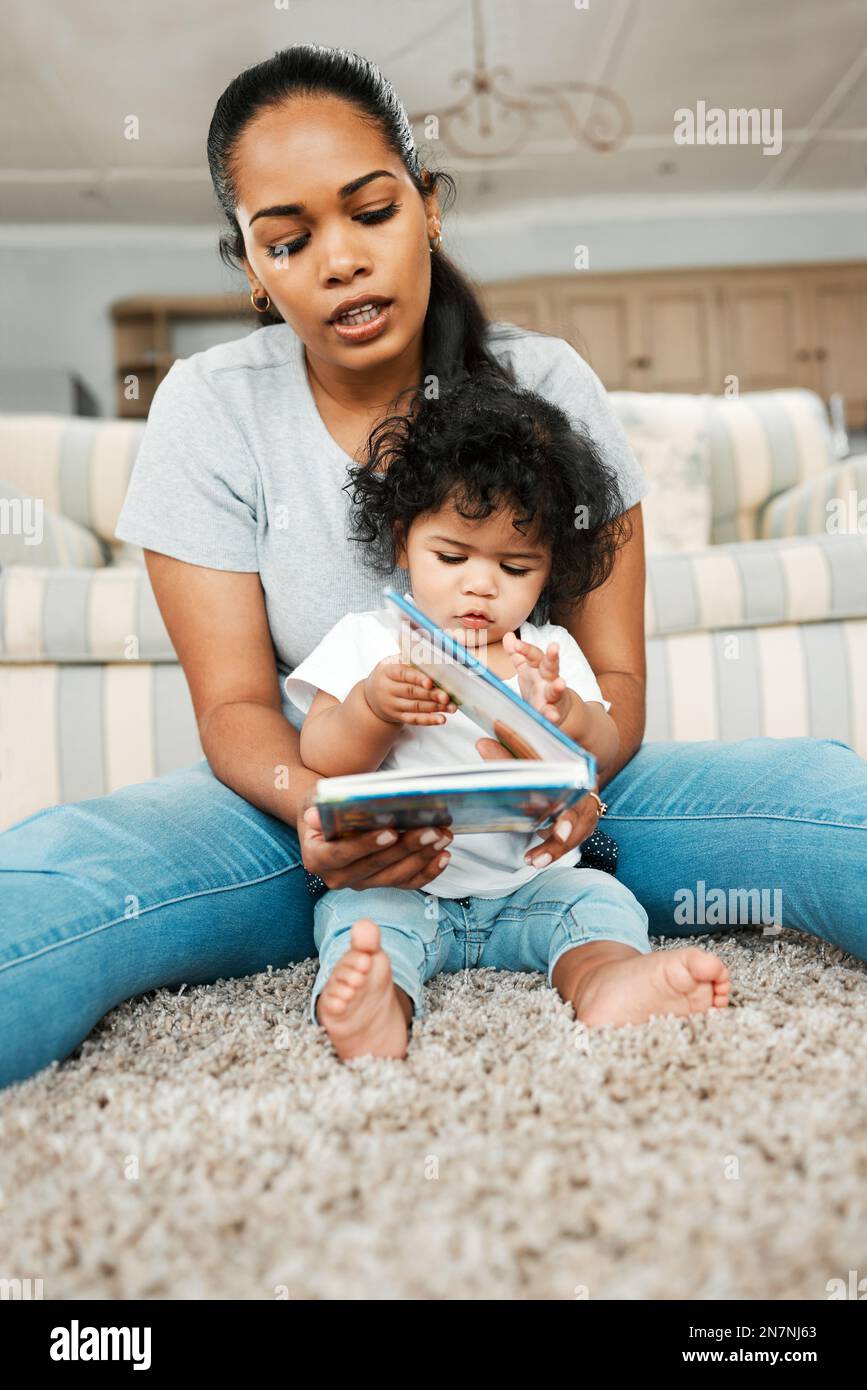 Being a good mother. a young mother reading to her baby girl Stock ...