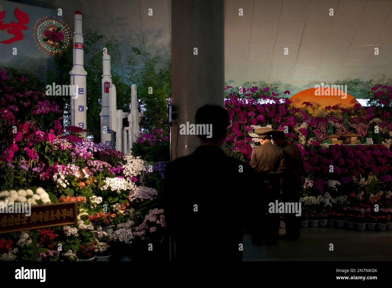 Two military officers admire displays at a flower show featuring ...