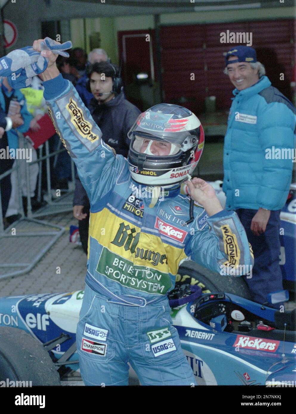 Michael Schumacher raises a victory fist to cheering fans as he puts ...