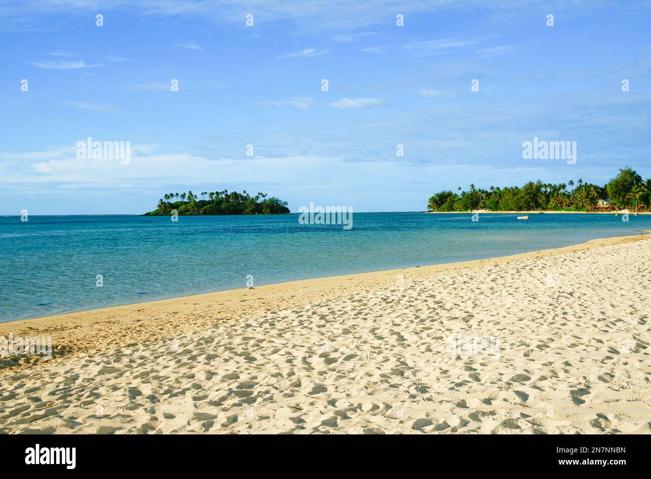 Beach background with small palm covered off-shore island from under ...