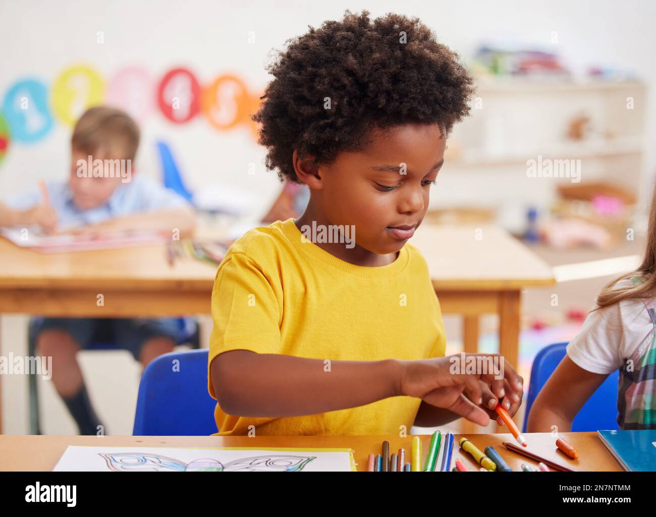 Colouring promotes creativity. a preschooler colouring in class Stock ...