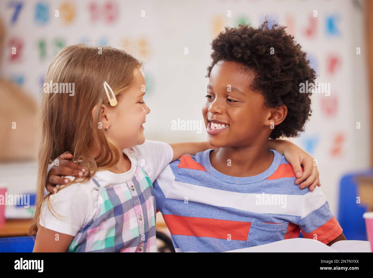 Ive made a new friend in class. two preschool students sitting together ...