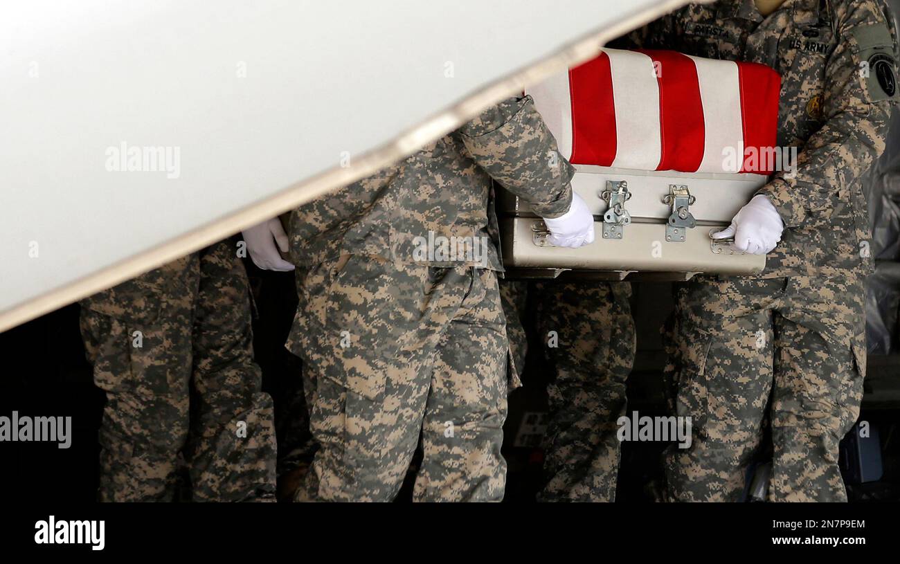 An Army carry team moves a transfer case containing the remains of U.S ...