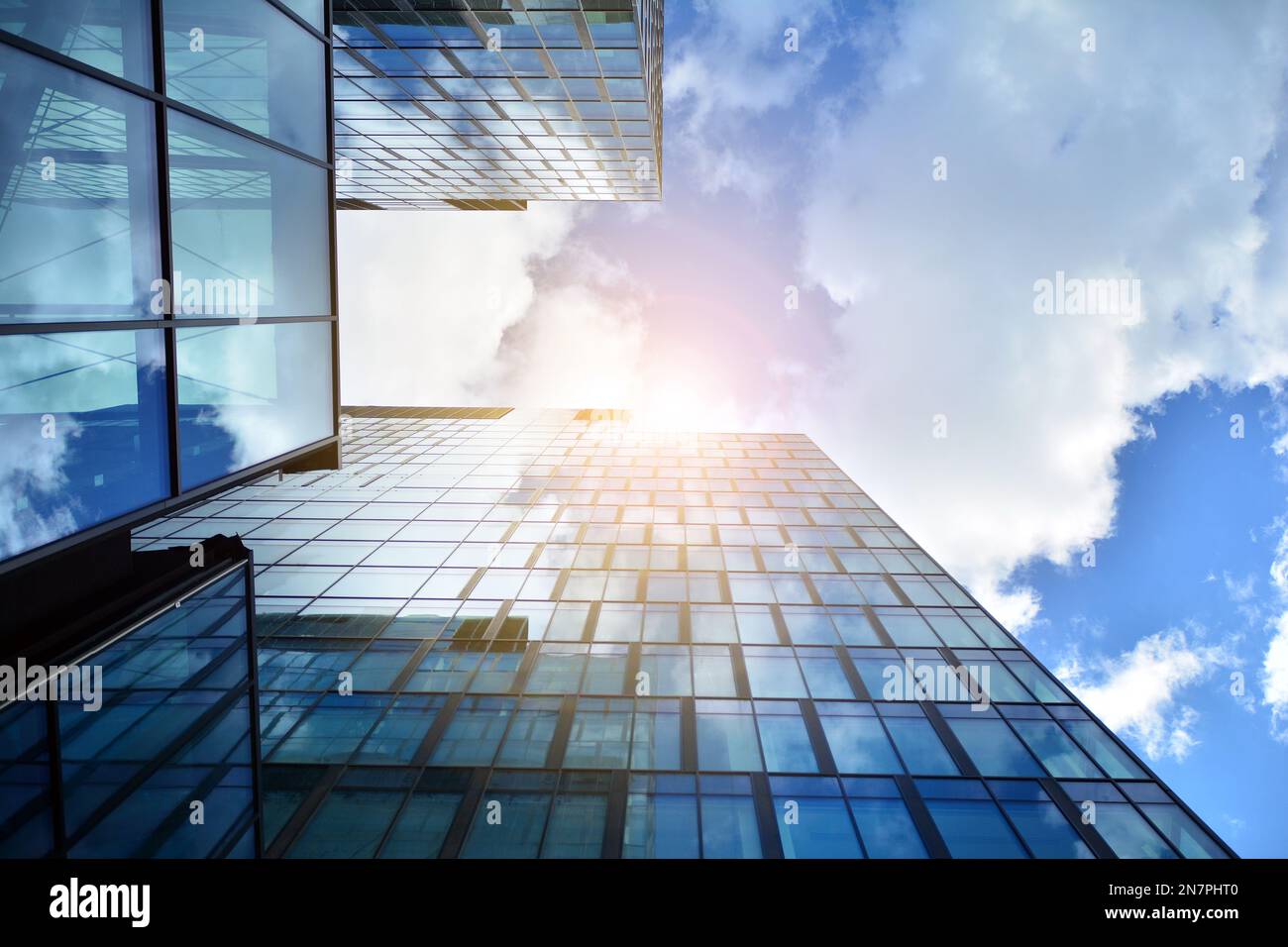 Bottom view of modern skyscrapers in business district against blue sky ...