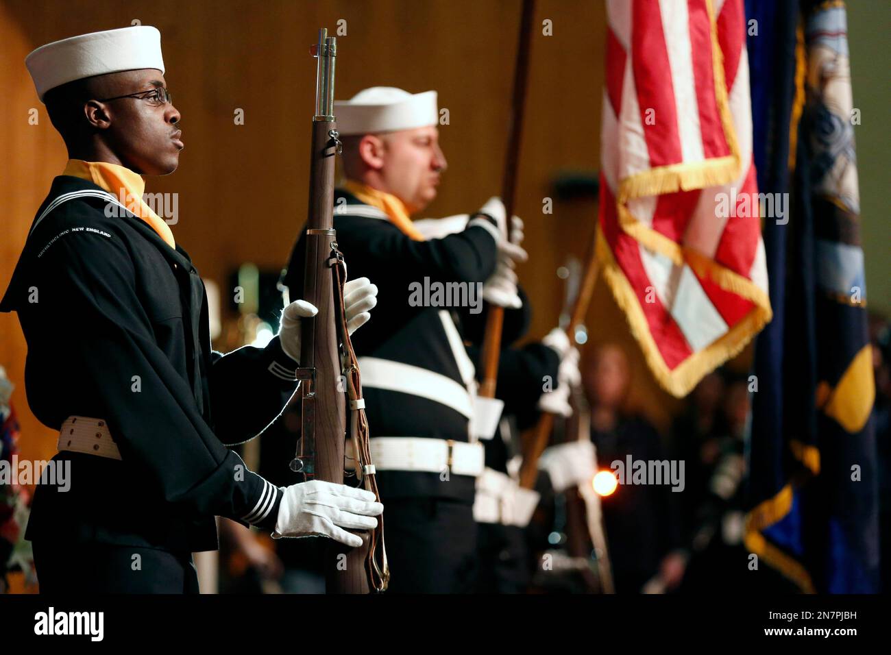 A military color guard stands at attention during a service marking the ...