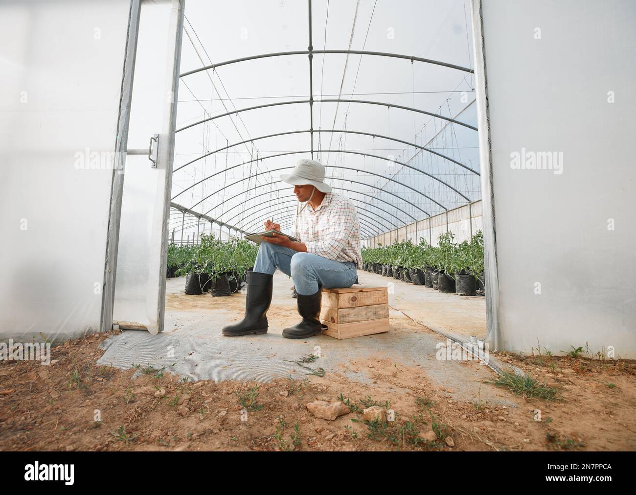 A thriving farm requires tons of planning. a young man writing notes ...