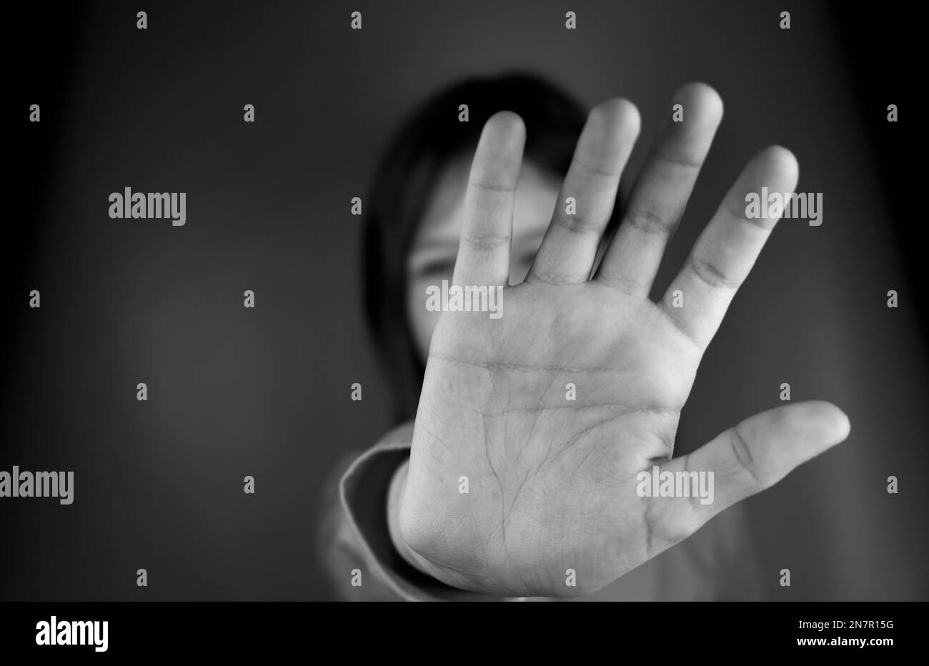 Girl showing stop sign gesture black and white photo. The child shows a ...
