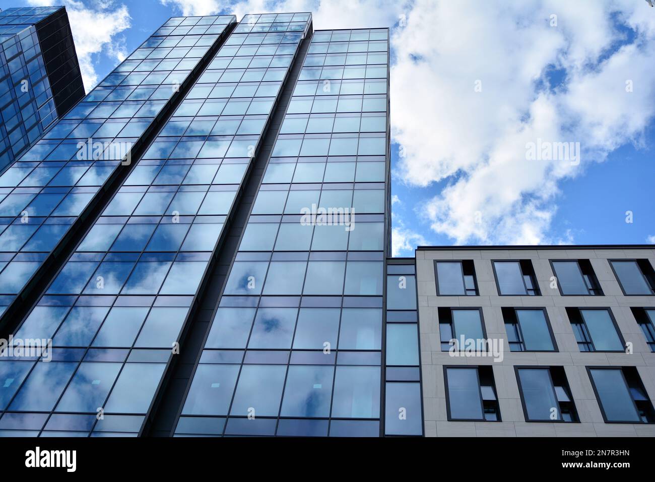 Bottom view of modern skyscrapers in business district against blue sky ...
