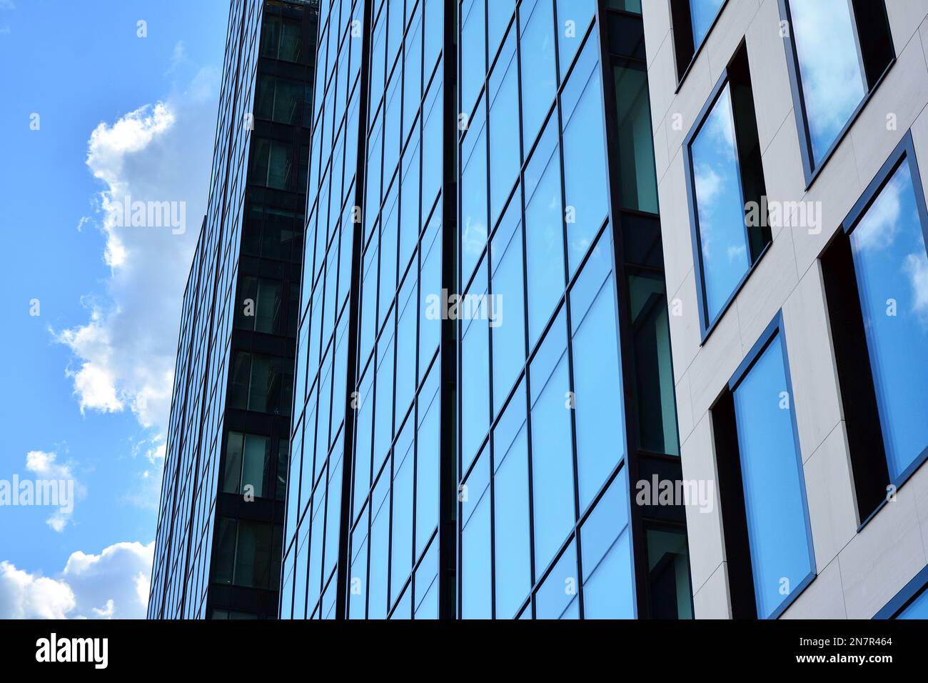 Bottom view of modern skyscrapers in business district against blue sky ...