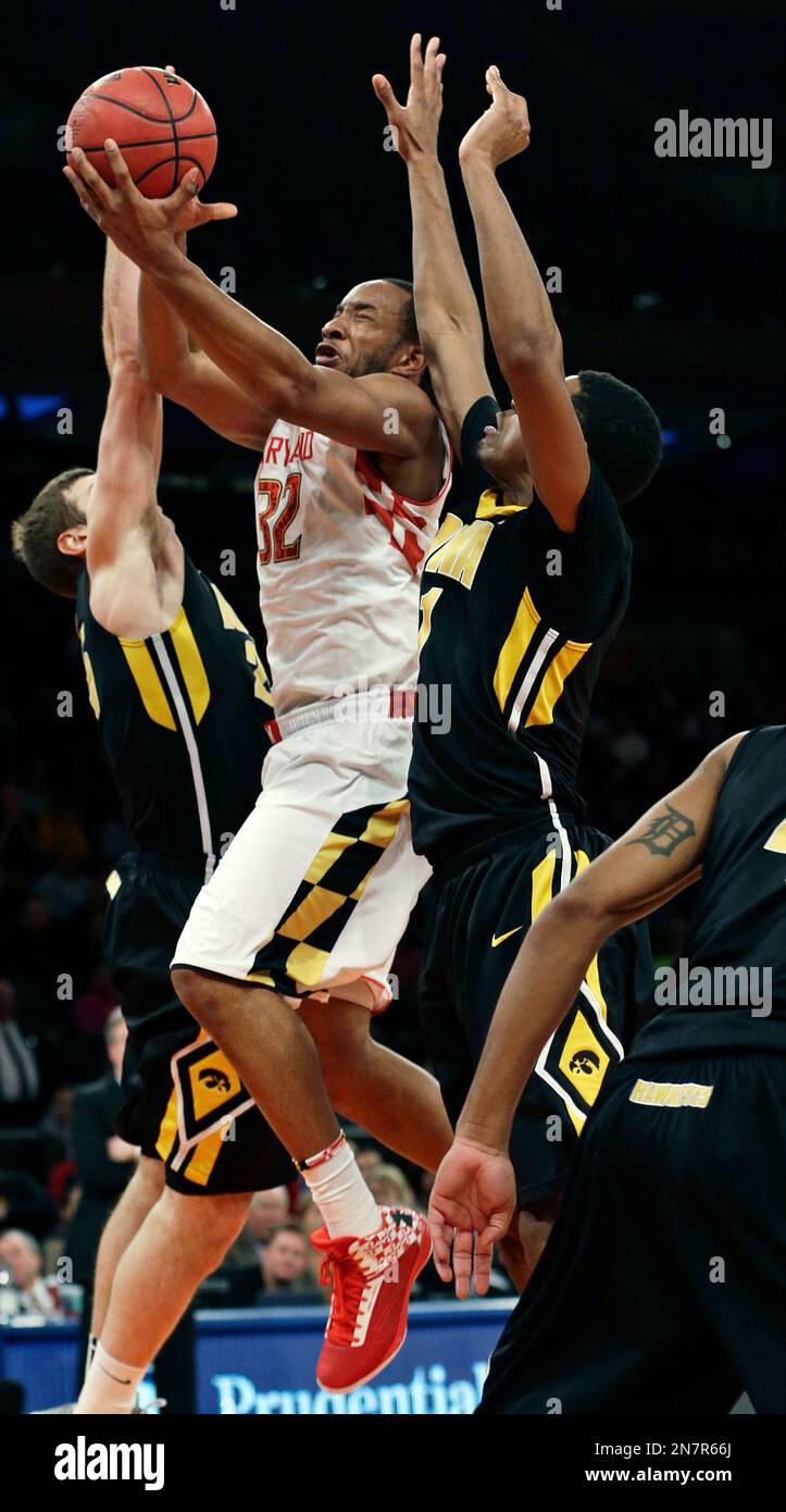 Maryland's Dez Wells (32) drives past Iowa's Melsahn Basabe, right, and ...