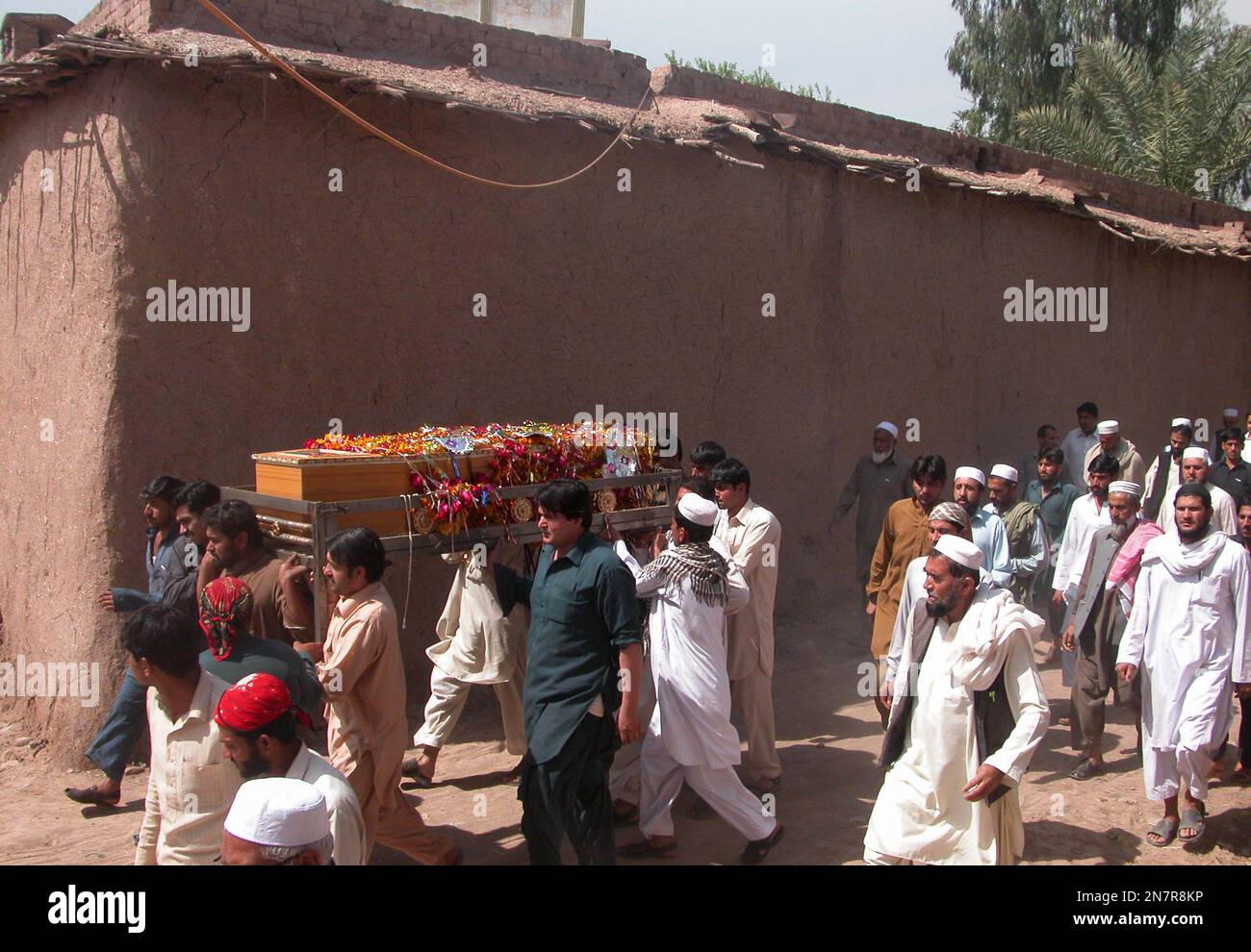 Pakistani villagers carry the body of a community police officer killed ...