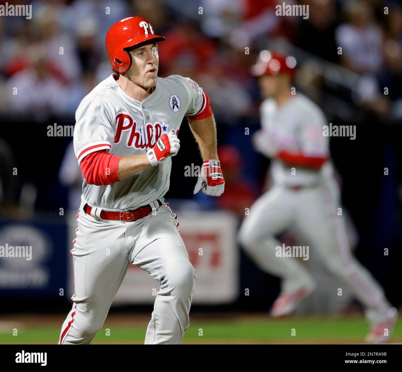 Philadelphia Phillies' Chase Utley, left, runs to first base after ...