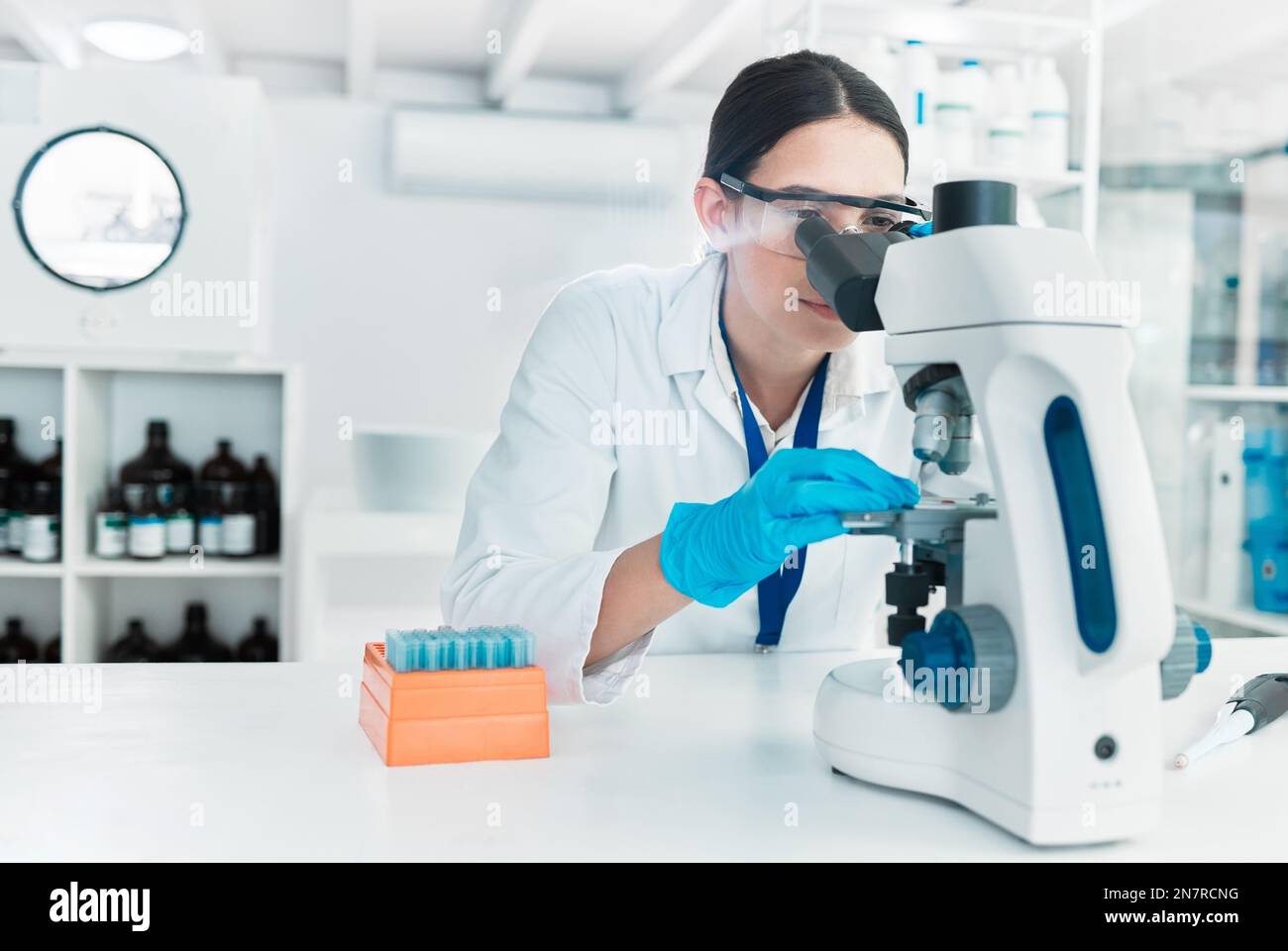 Let me take another look. a young scientist using a microscope in a lab ...