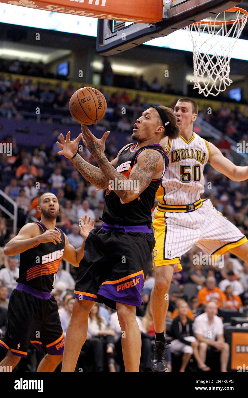 Phoenix Suns' Michael Beasley, center, grabs a rebound in front of ...
