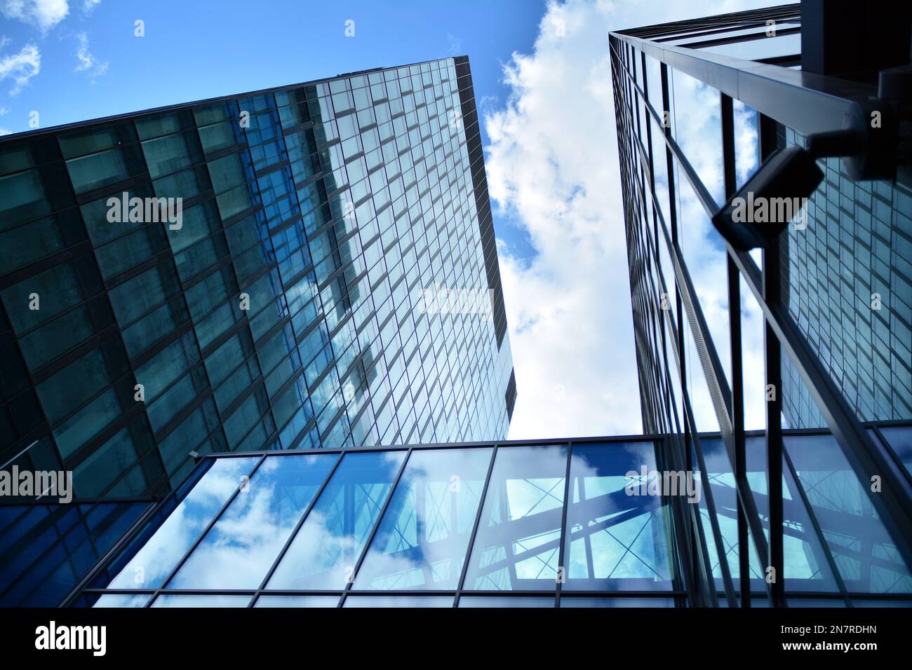 Bottom view of modern skyscrapers in business district against blue sky ...