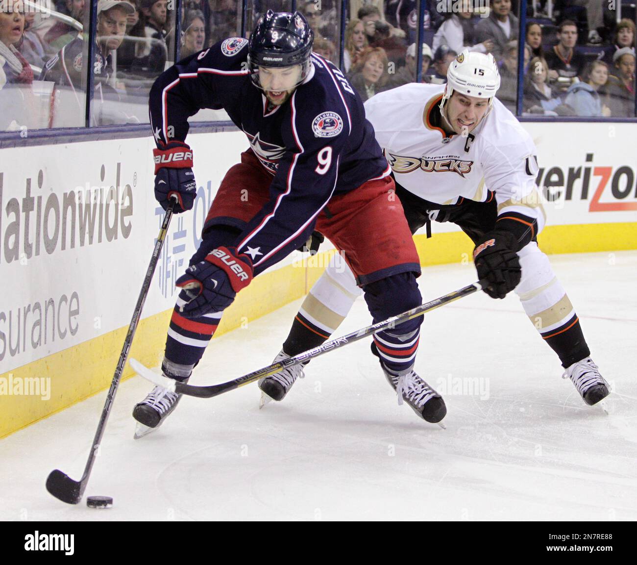 Columbus Blue Jackets' Colton Gillies, left, carries the puck behind ...