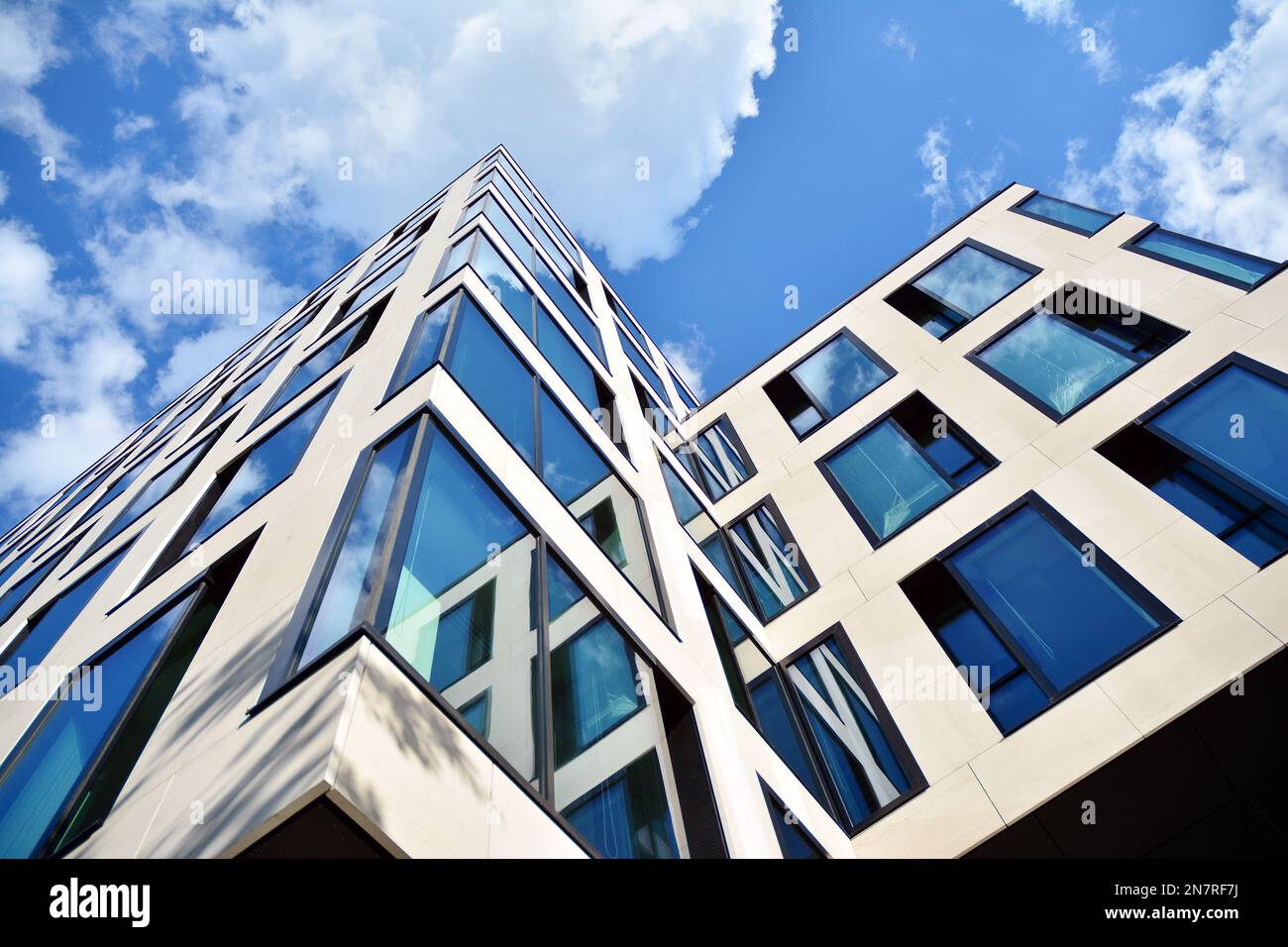 Bottom view of modern skyscrapers in business district against blue sky ...