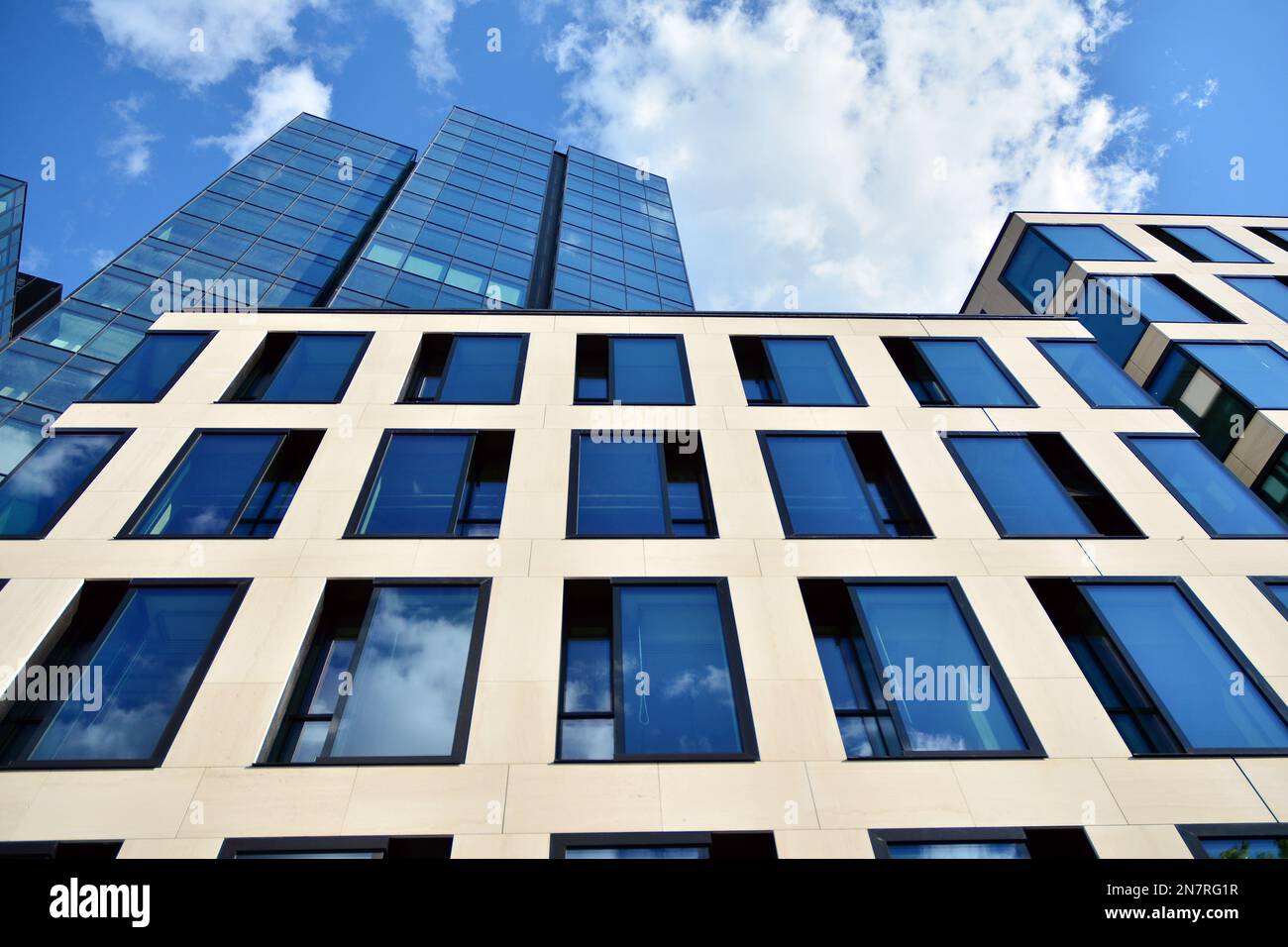 Bottom view of modern skyscrapers in business district against blue sky ...