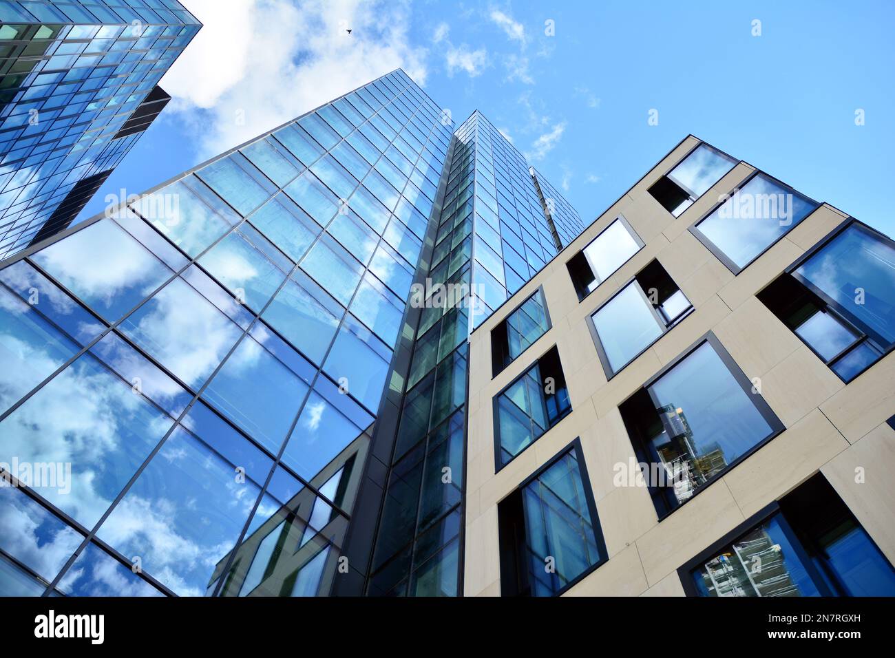 Bottom view of modern skyscrapers in business district against blue sky ...