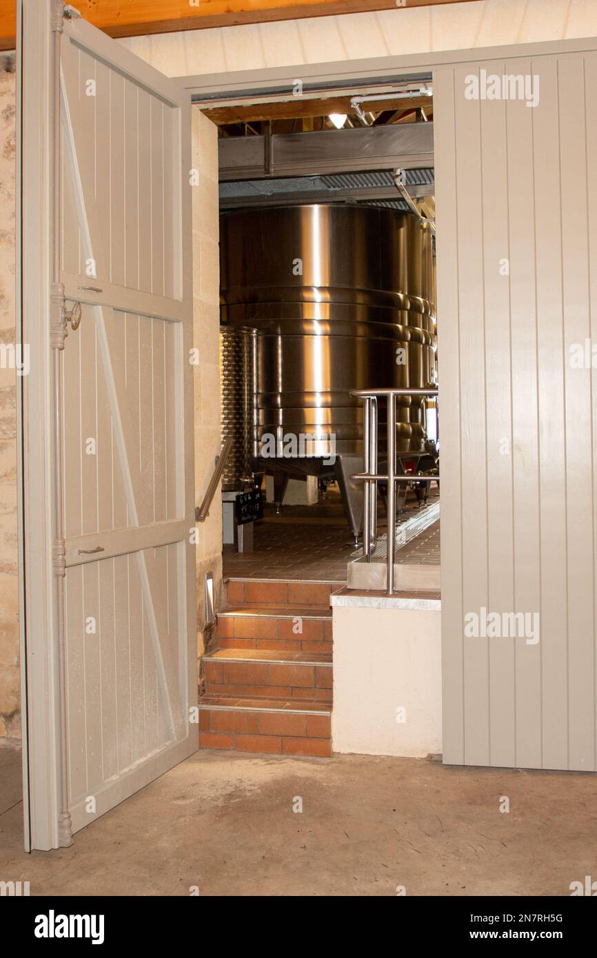Modern aluminum barrels after wood door in wine cellar Stock Photo - Alamy