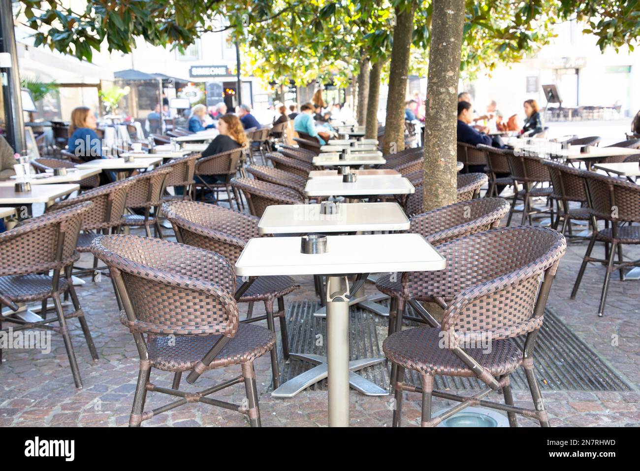 Scenic Street view with cafe terrace and tree Stock Photo - Alamy