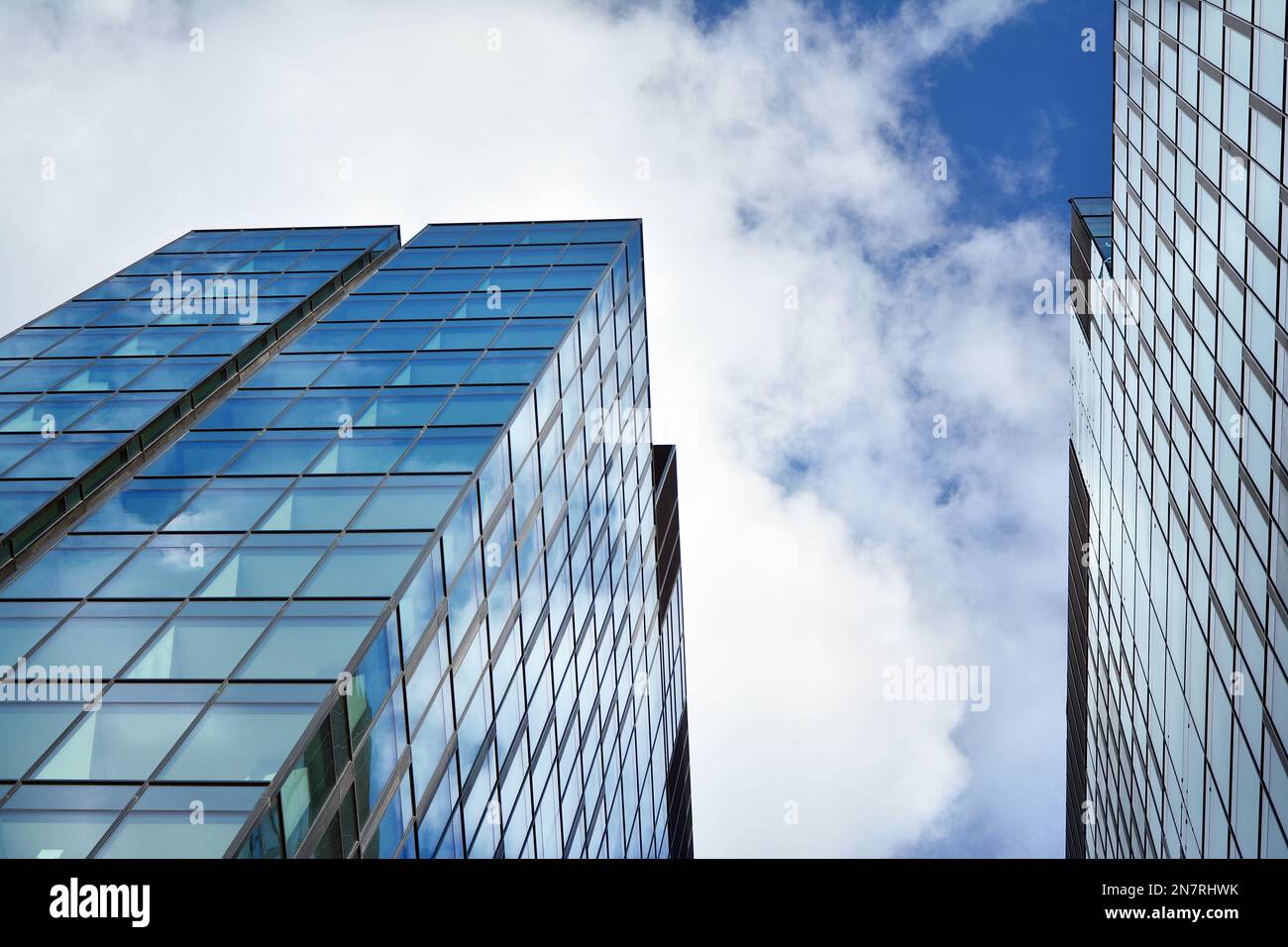 Bottom view of modern skyscrapers in business district against blue sky ...