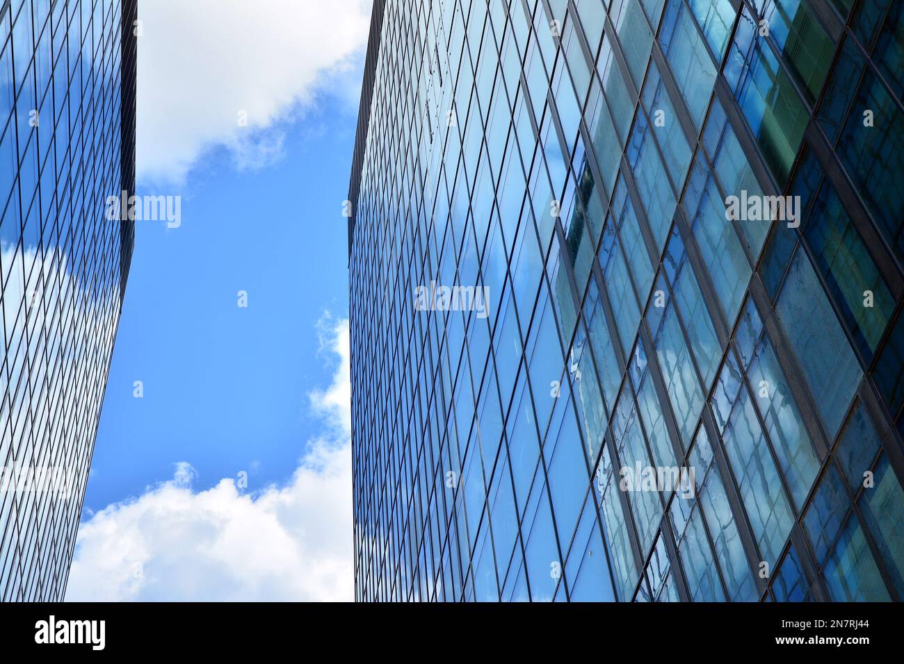 Bottom view of modern skyscrapers in business district against blue sky ...
