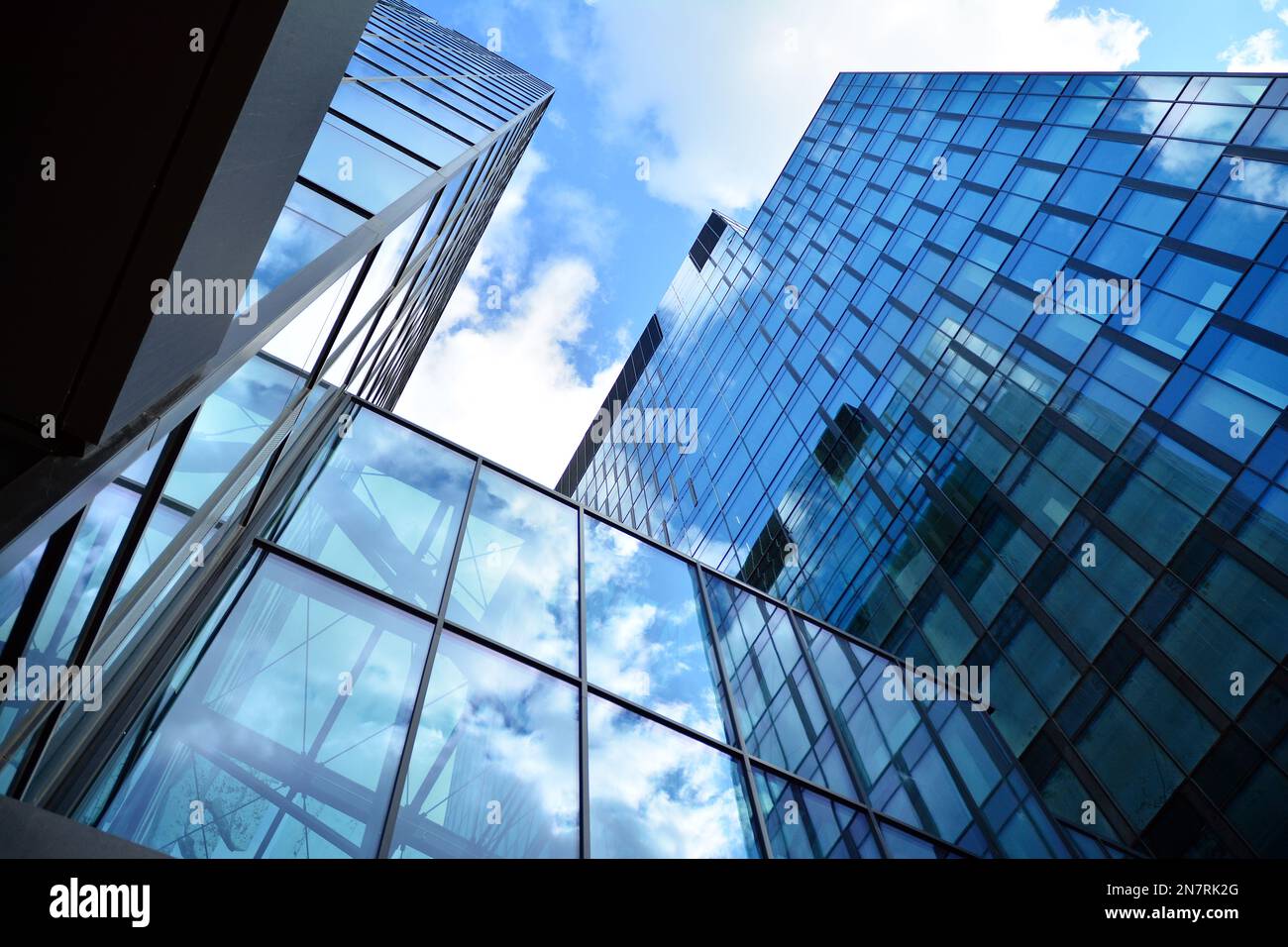 Bottom view of modern skyscrapers in business district against blue sky ...