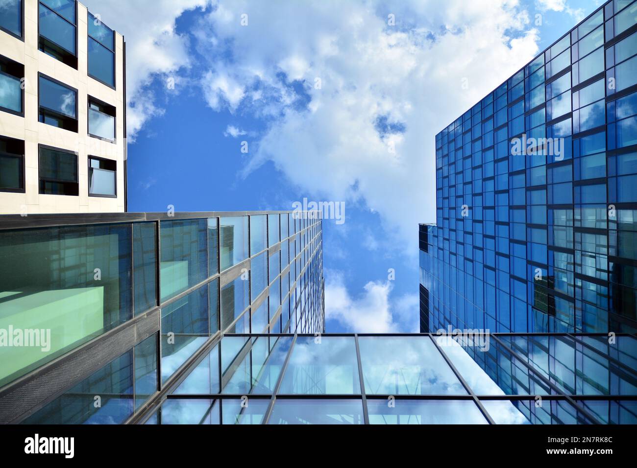 Bottom view of modern skyscrapers in business district against blue sky ...