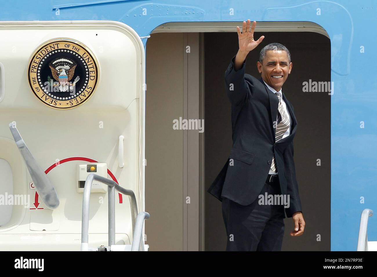 President Barack Obama waves as he boards Air Force One for his ...