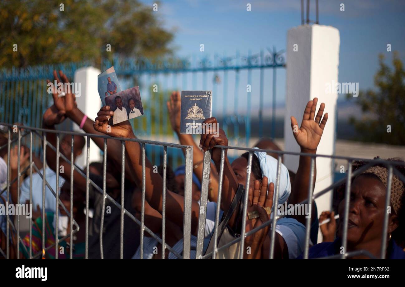 Worshippers hold up family pictures and passports, as a symbol of their ...