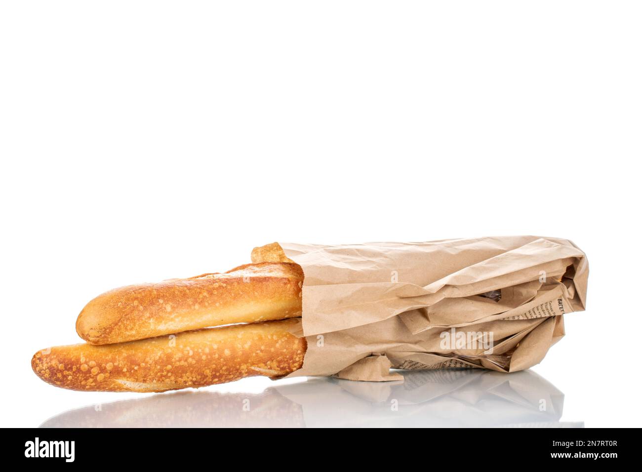 Two aromatic baguettes in a paper bag, macro isolated on white ...