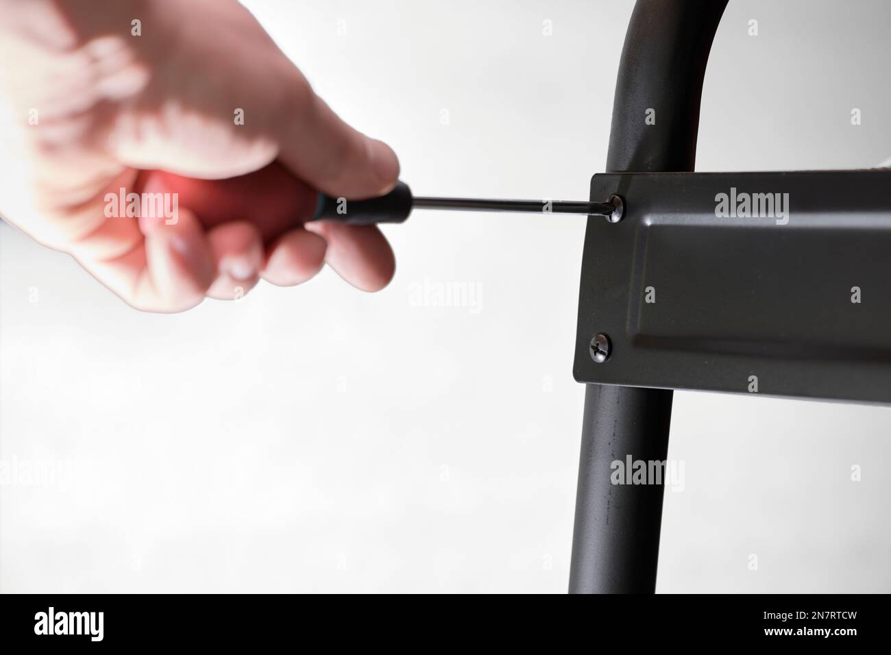 Hand with screwdriver tool, works on steel construction. Professions in ...