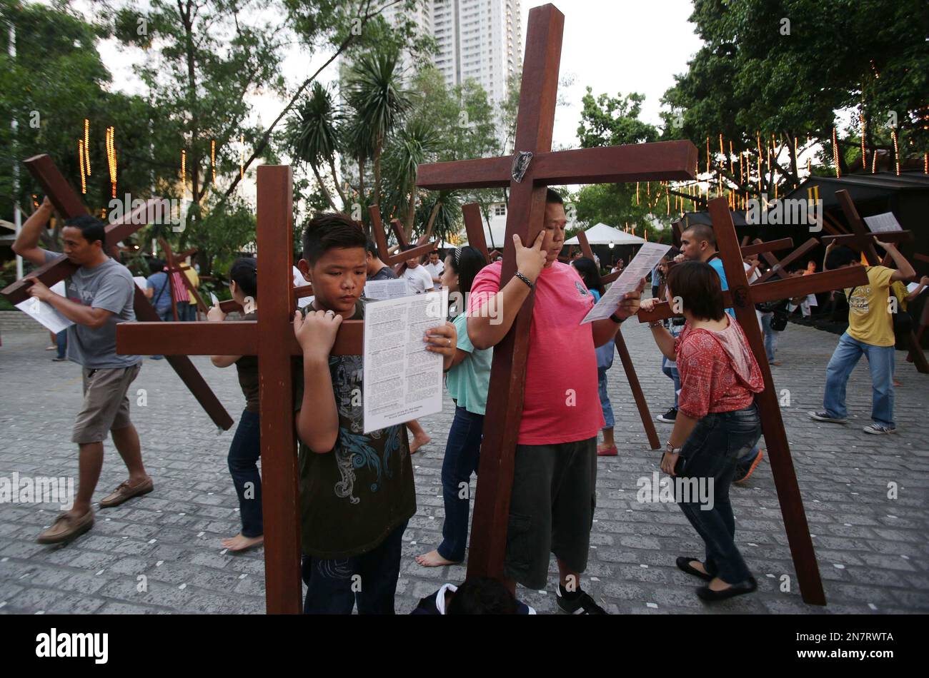 Filipino devotees make the Stations of the Cross as they carry wooden ...