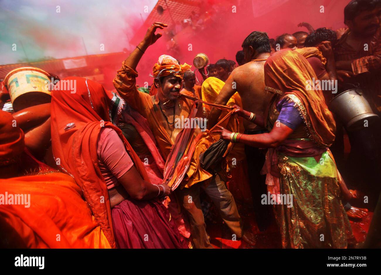 Indian Hindu women playfully tear apart clothes of a man during ...