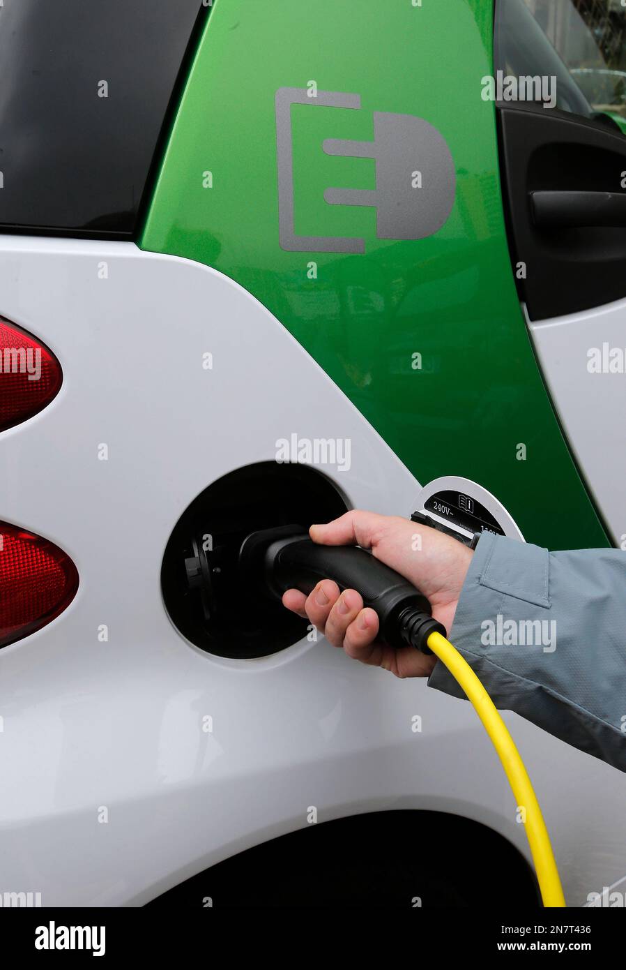 A demonstrator plugs in a "Smart fortwo "electric car, shown at the ...