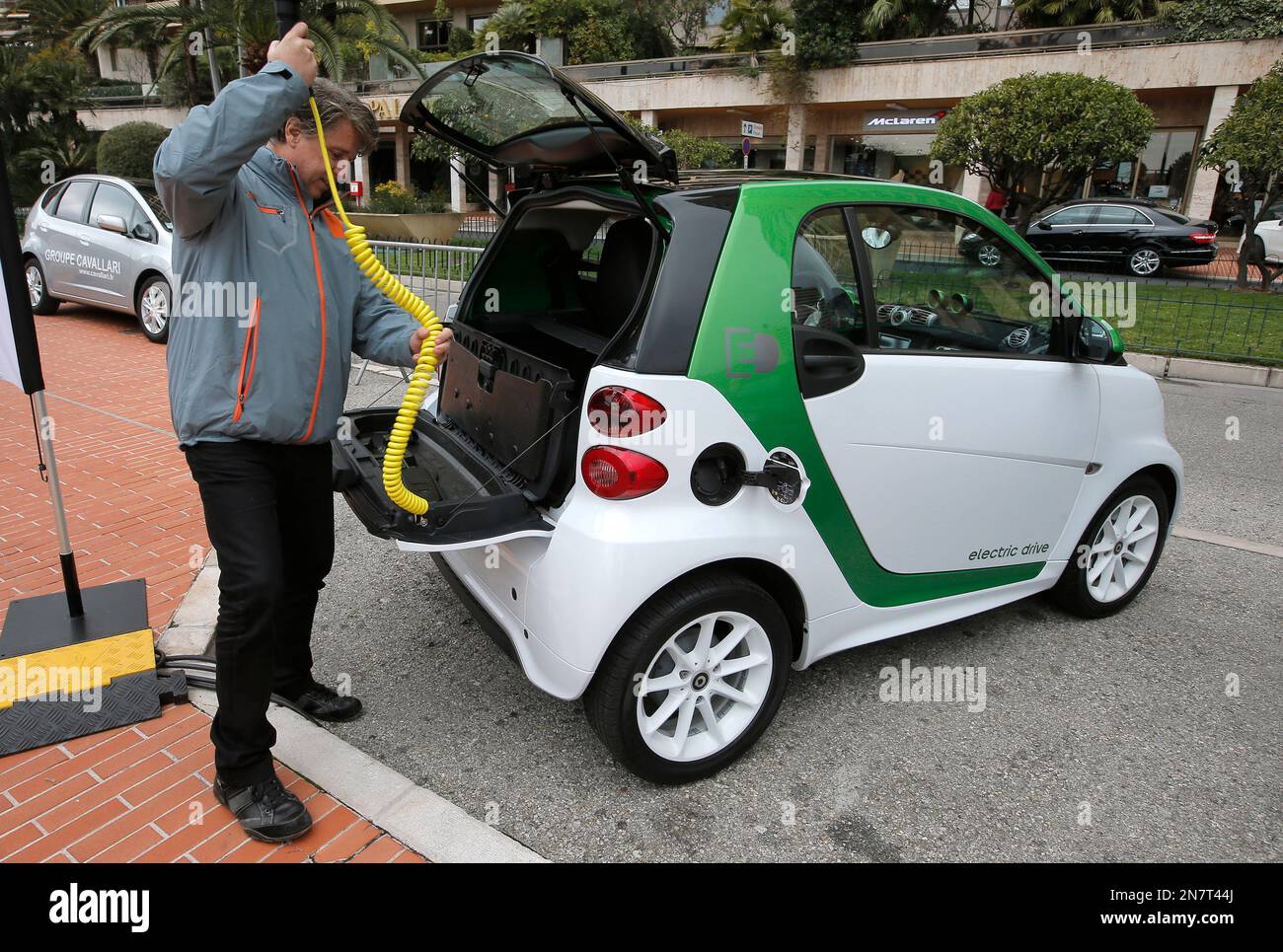 A demonstrator plugs in a "Smart fortwo "electric car, during the EVER ...
