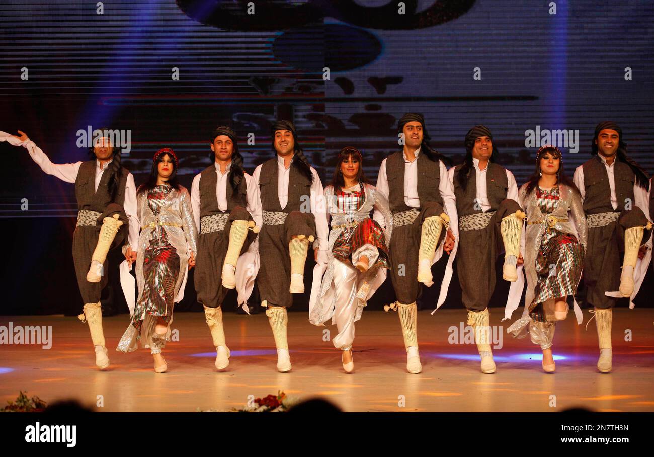 Dancers wearing traditional Iraqi folk costumes perform during a ...