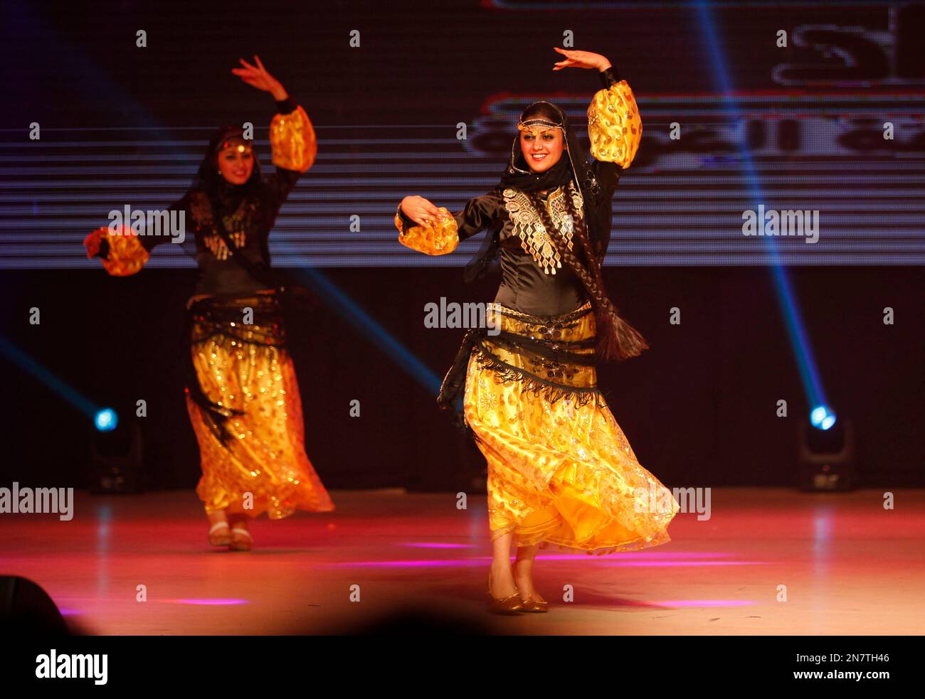 Dancers wearing traditional Iraqi folk costumes perform during a ...