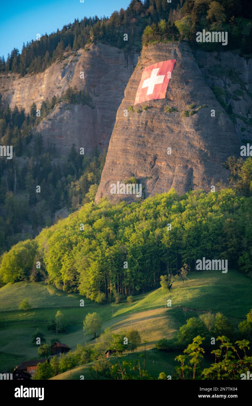 The swiss flag placed on a steep mountain Stock Photo - Alamy