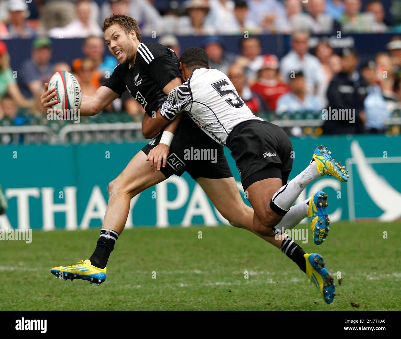 Tim Mikkelson of New Zealand, left is tackled by Fiji's Ilai Tinai ...