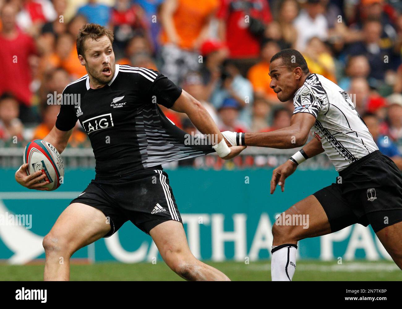 Tim Mikkelson of New Zealand, left is tackled by Fiji's Ilai Tinai ...