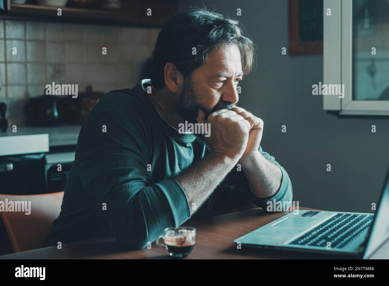 One mature man at home using laptop worried by house problems. People ...