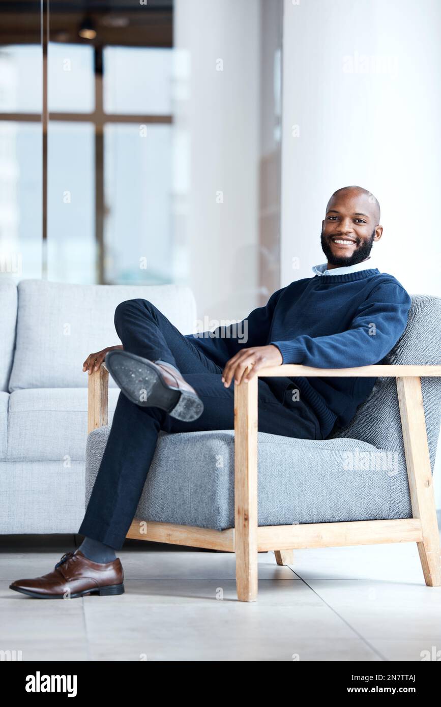 Portrait, black man in office and waiting on chair, smile and confident ...